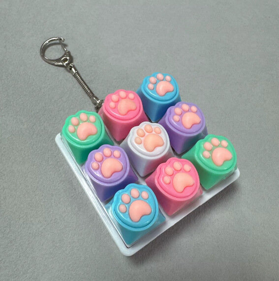 Многоцветная 9-кнопочная антистрессовая силиконовая игрушка-кнопка в виде кошачьей лапки с мультяшным рисунком для тестирования клавиатуры.