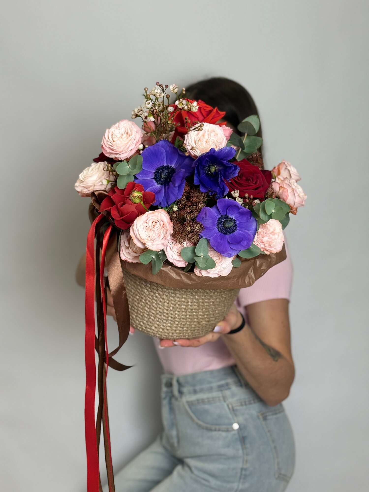 Анемоны, кустовые розы , розы и хамелациум в яркой интерьерной композиции в кашпо «Сказочная страна»