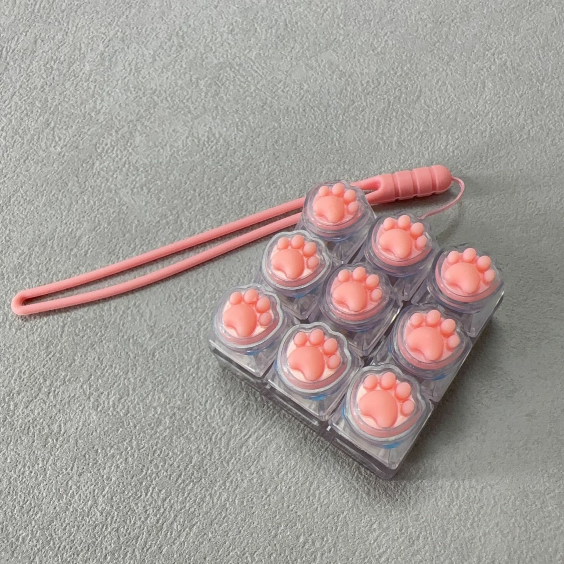 Многоцветная 9-кнопочная антистрессовая силиконовая игрушка-кнопка в виде кошачьей лапки с мультяшным рисунком для тестирования клавиатуры.