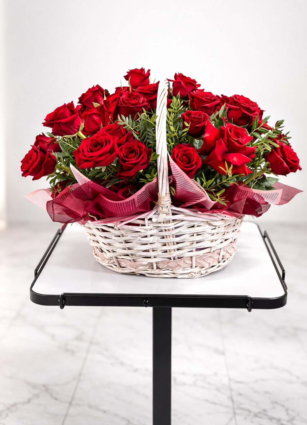 Изысканная композиция из 25 алых роз с нежной зеленью фисташки в плетёной корзине.