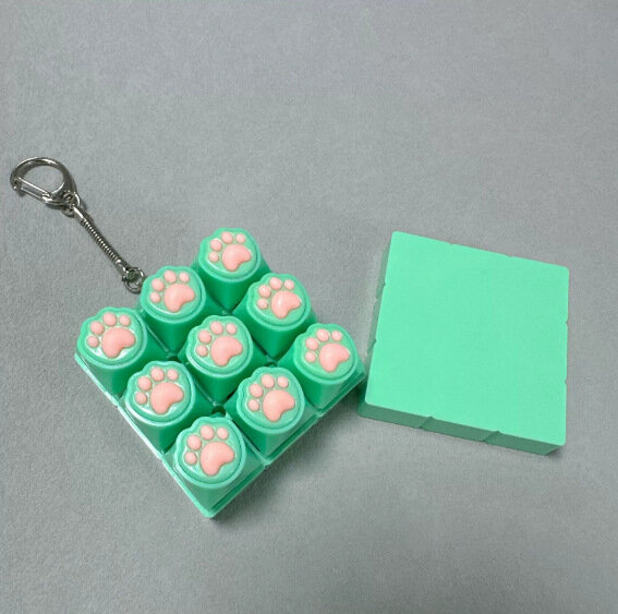 Многоцветная 9-кнопочная антистрессовая силиконовая игрушка-кнопка в виде кошачьей лапки с мультяшным рисунком для тестирования клавиатуры.