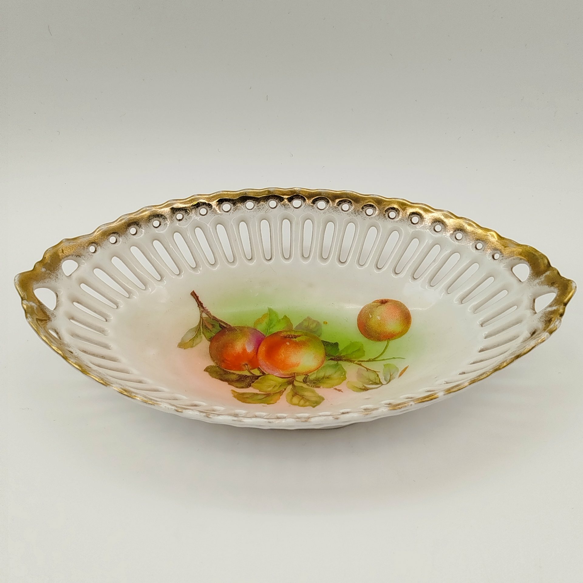 Сухарница овальной формы с прорезным бортом, украшенная изображением яблок