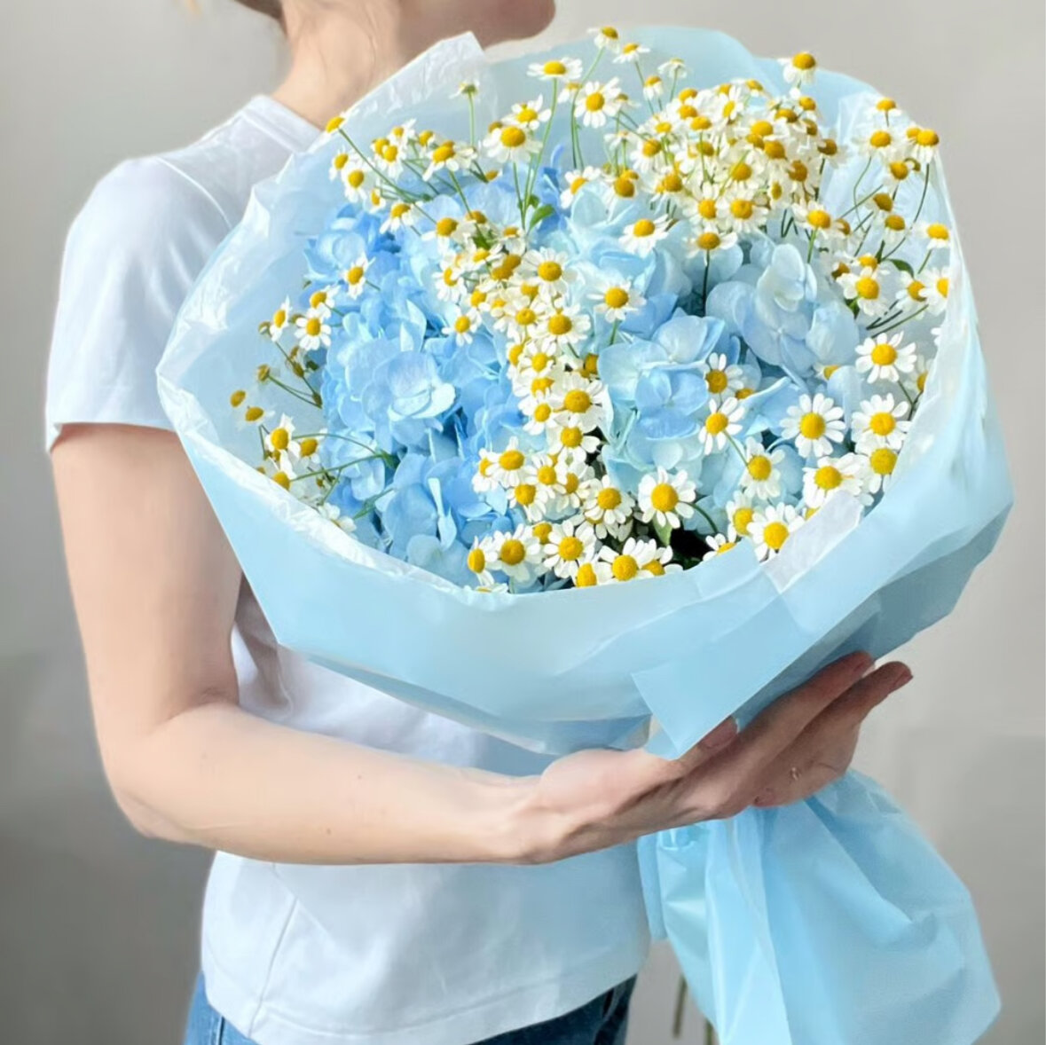 Сборный букет Мира из 3 голубых гортензий и 6 кустовых ромашек в матовой пленке с атласной лентой.