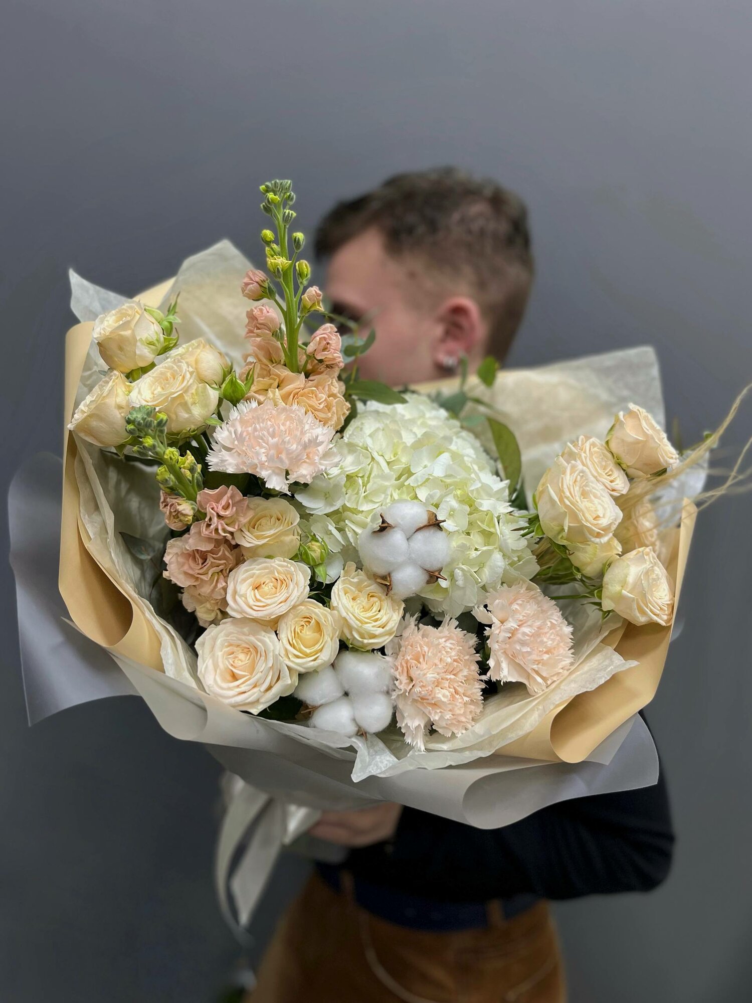 Букет из кустовых пионовидных роз, гортензии, маттиол, гвоздик с хлопком и стифой в кремовой плёнке