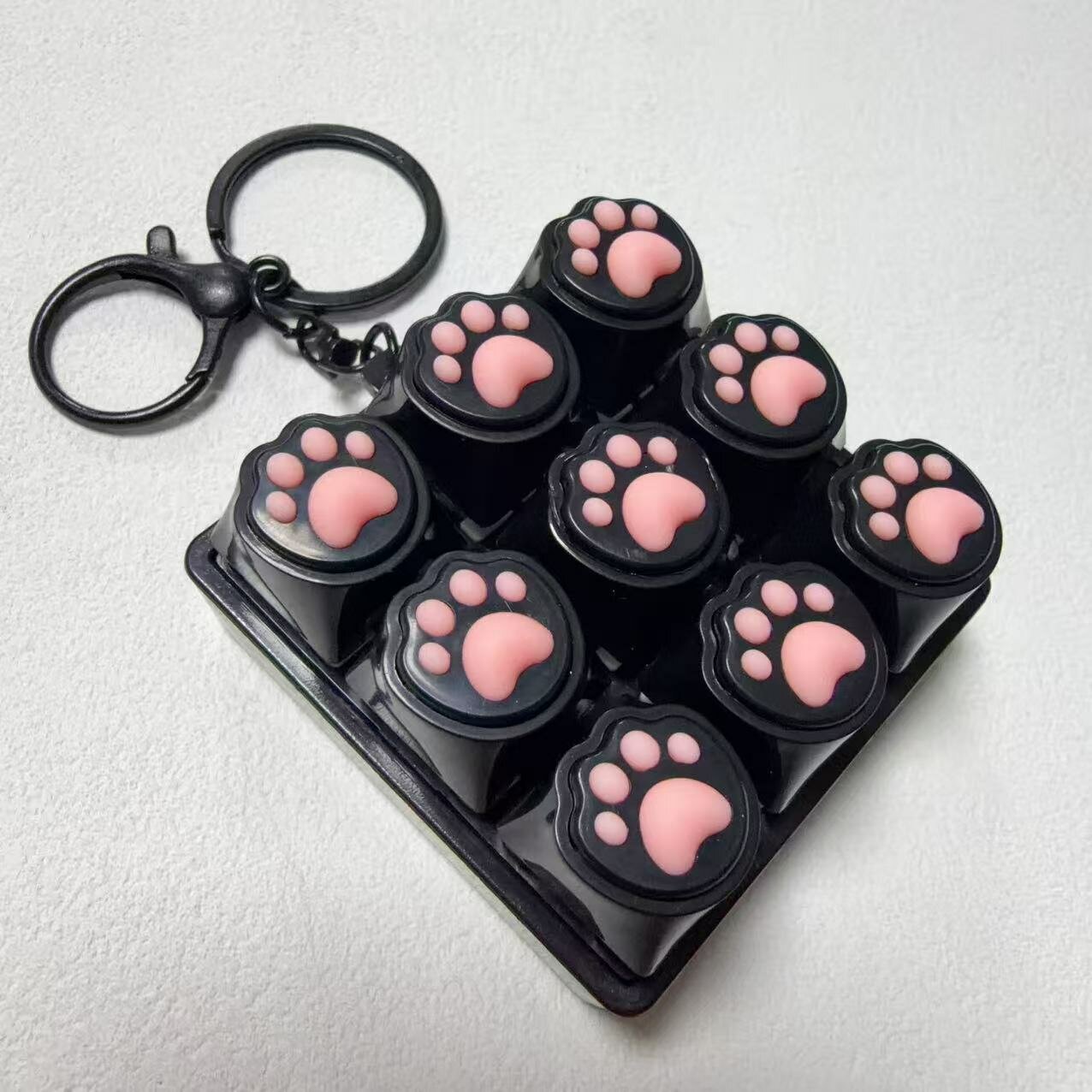 Многоцветная 9-кнопочная антистрессовая силиконовая игрушка-кнопка в виде кошачьей лапки с мультяшным рисунком для тестирования клавиатуры.