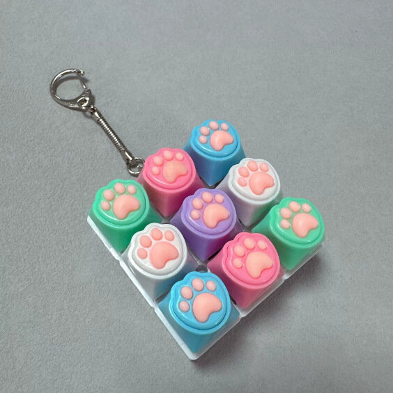 Многоцветная 9-кнопочная антистрессовая силиконовая игрушка-кнопка в виде кошачьей лапки с мультяшным рисунком для тестирования клавиатуры.