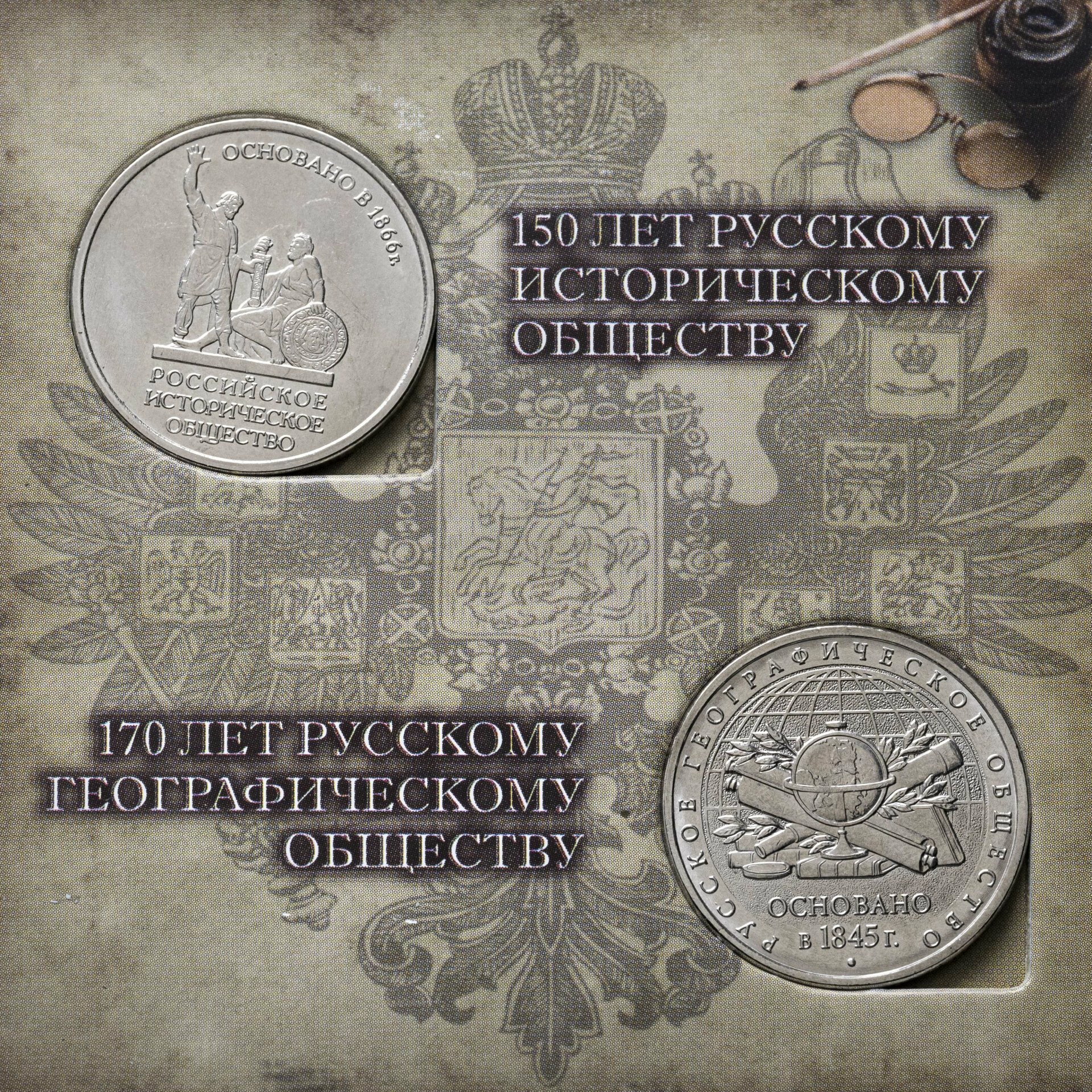 Две монеты 5 рублей в буклете "150 лет Русскому Историческому" и "170 лет Русскому Географическому Обществу", Сталь, в сохранности UNC