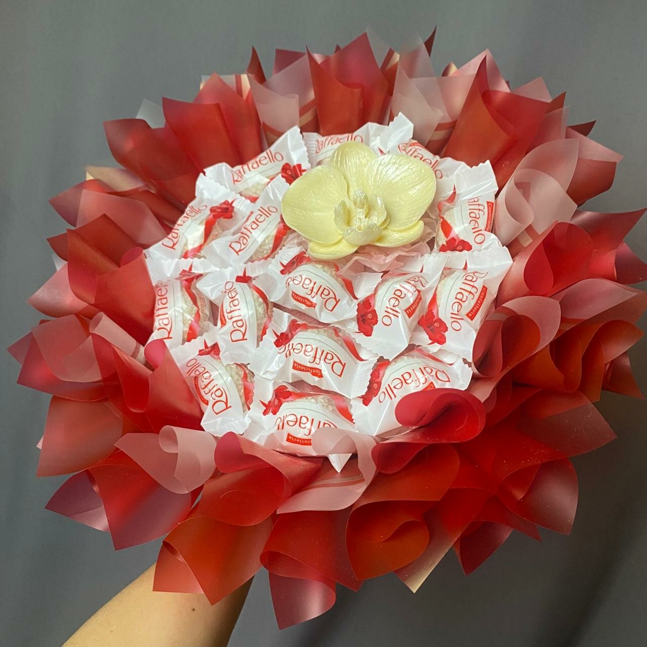 Букет с орхидеей из белого шоколада и воздушных конфет Рафаэлло в пышной упаковке