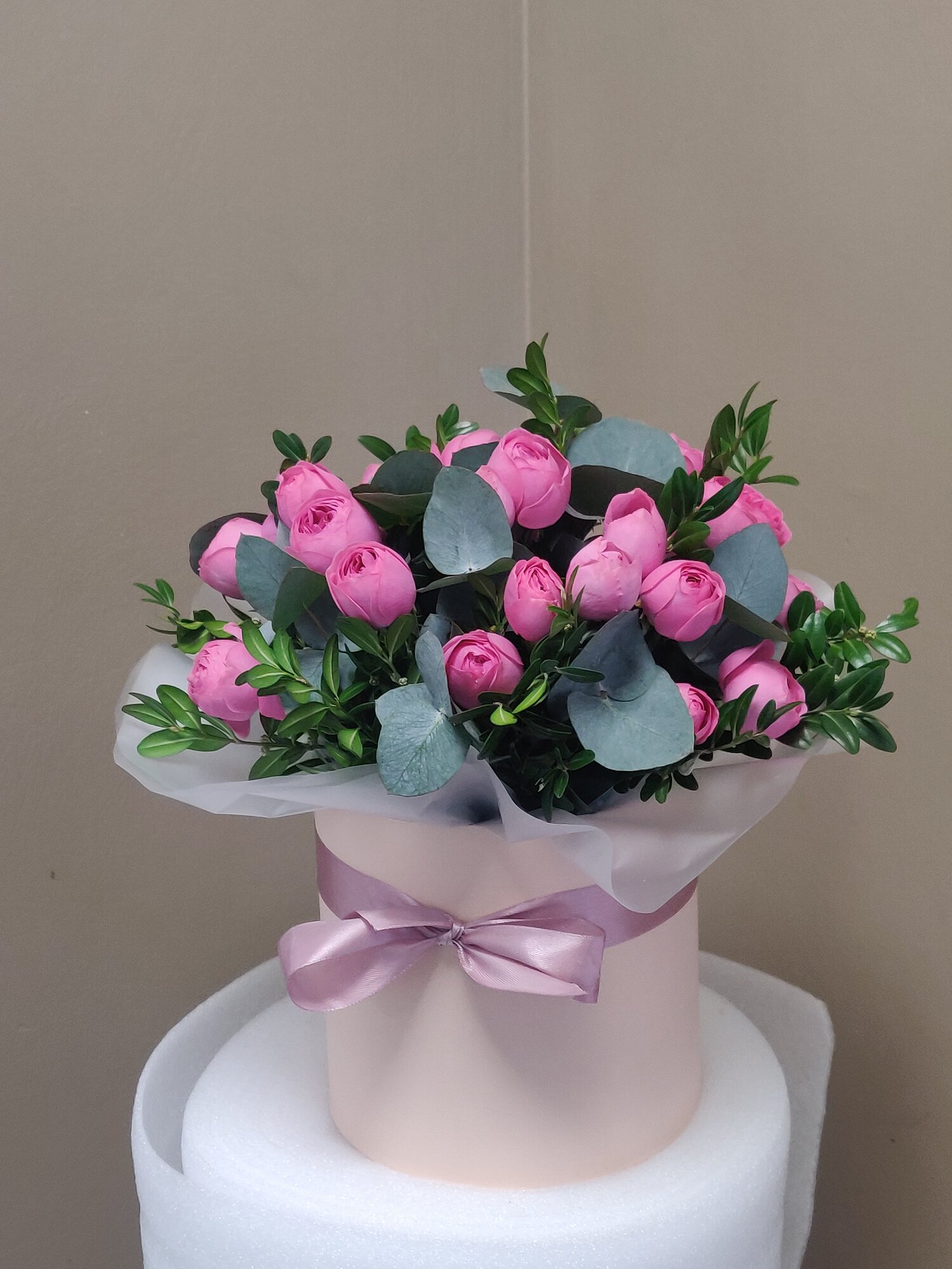 Необыкновенная композиция пионовидных кустовых роз п, с ароматным эвкалиптом в подарочной коробке.