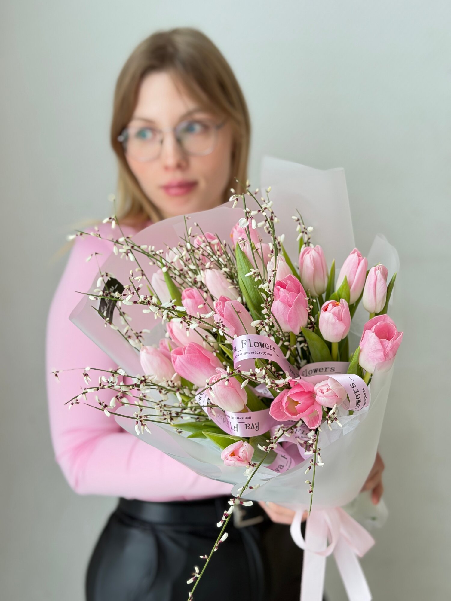 Розовые весенние тюльпаны и веточки цветущей генисты в стильной упаковке