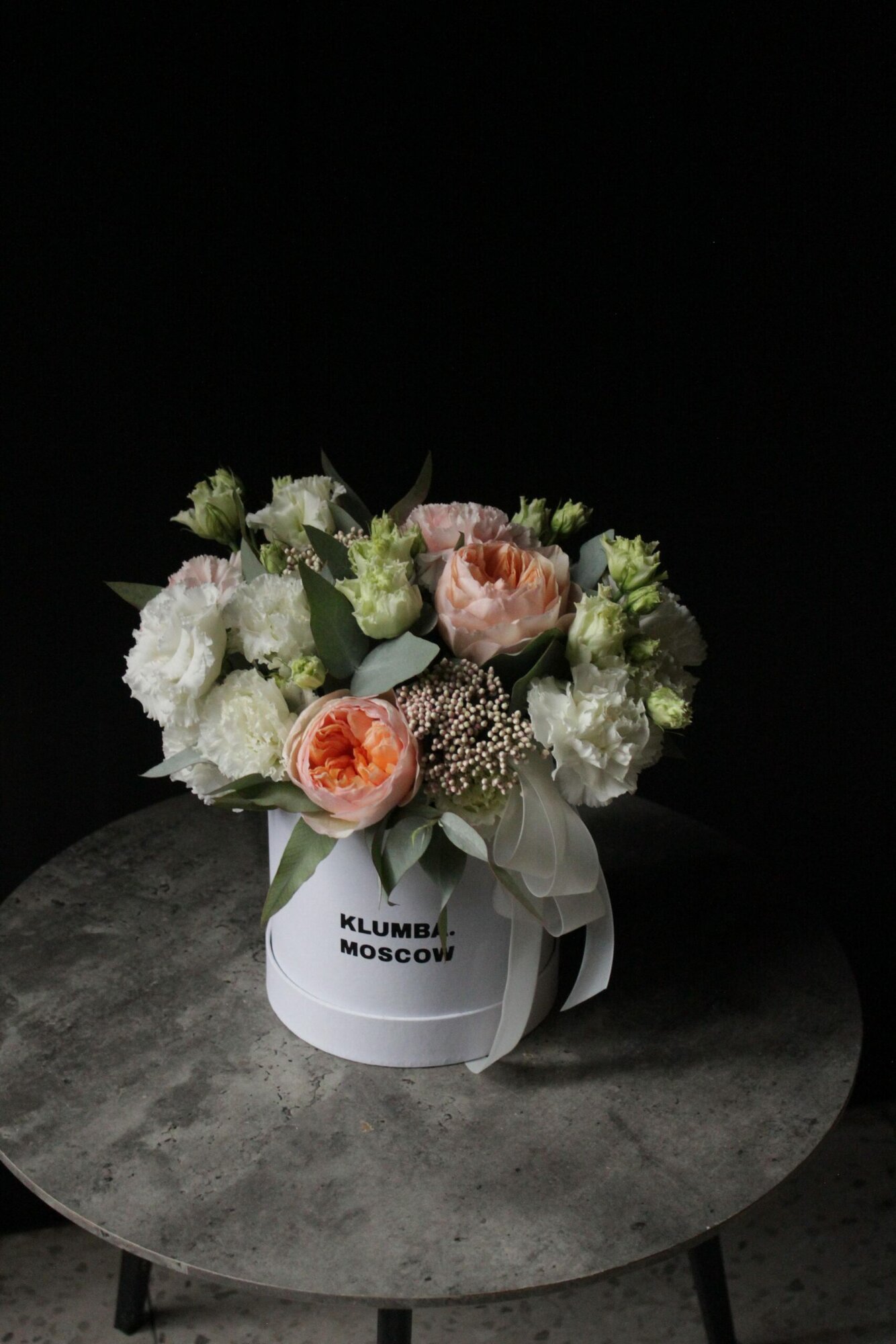 Композиция в шляпной коробке из роз и гвоздик от студии цветов клумба. москва