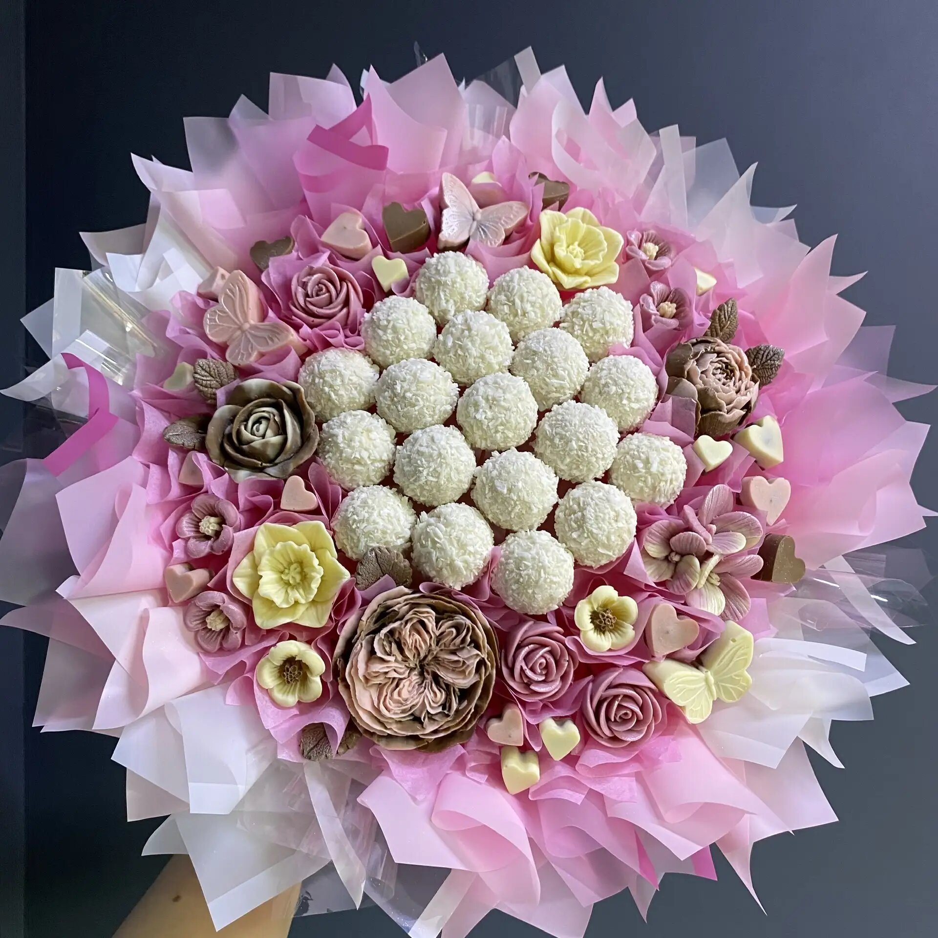 Нежный букет из шоколадных цветов, сердечек и воздушных Рафаэлло в пышной упаковке