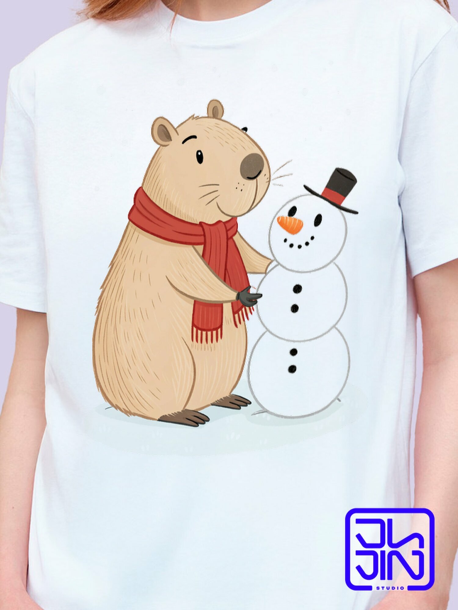 Футболка классическая женская с авторским принтом Веселая бежевая капибара со смешным снеговиком на песочном зимнем фоне, белый хлопковый трикотаж с прикольным рисунком на груди