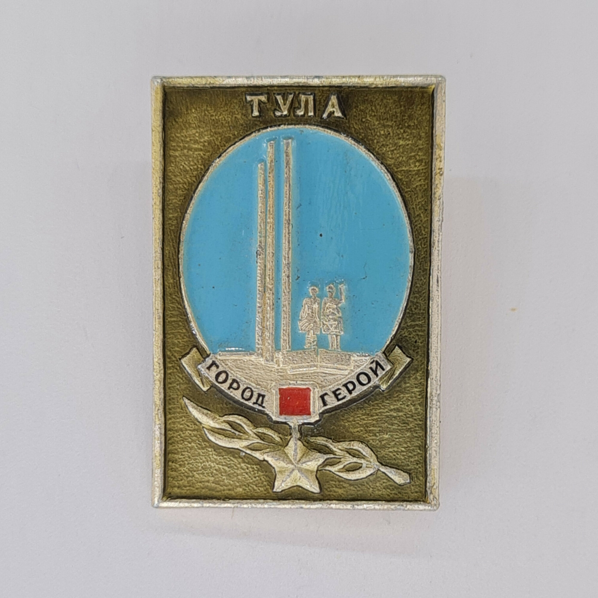 Значок СССР. Тула, город герой, стела и фигуры людей, городская тематика. Винтажный значек.
