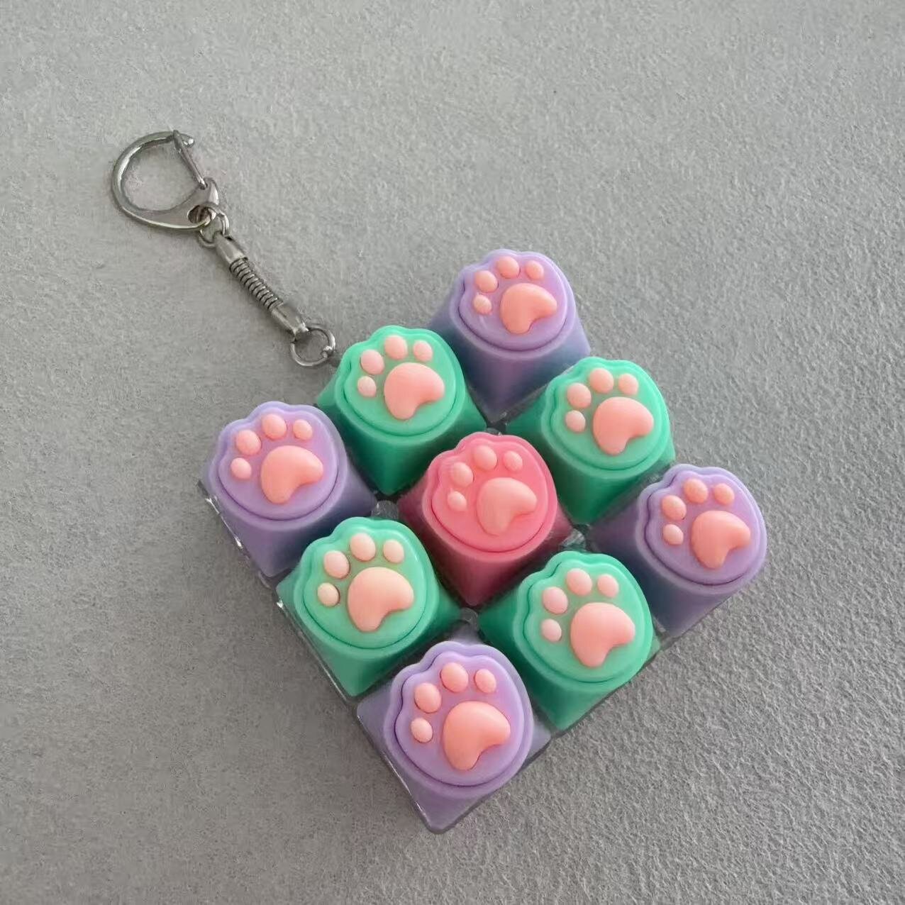 Многоцветная 9-кнопочная антистрессовая силиконовая игрушка-кнопка в виде кошачьей лапки с мультяшным рисунком для тестирования клавиатуры.