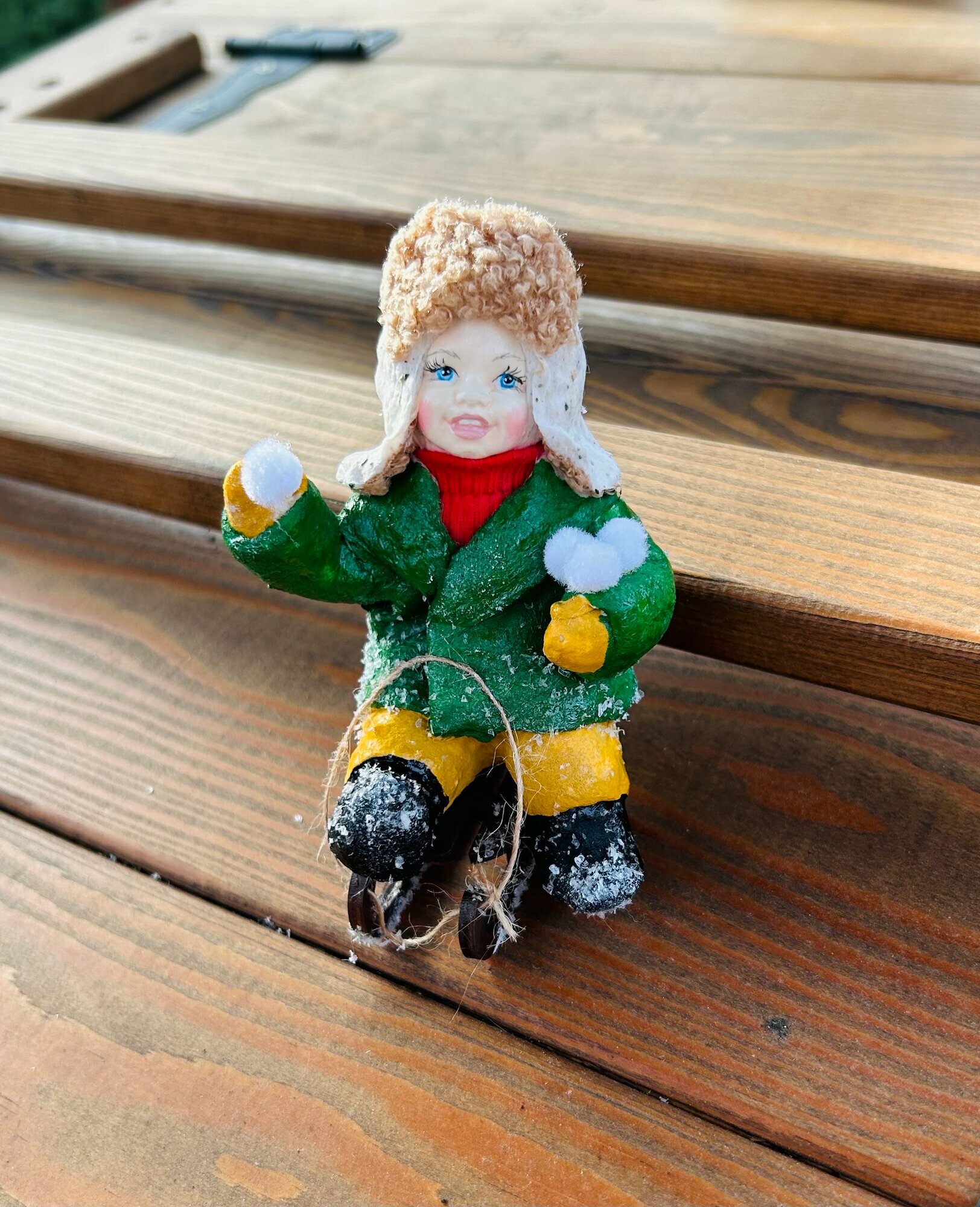 Ватная елочная игрушка-малыш на санках со снежками