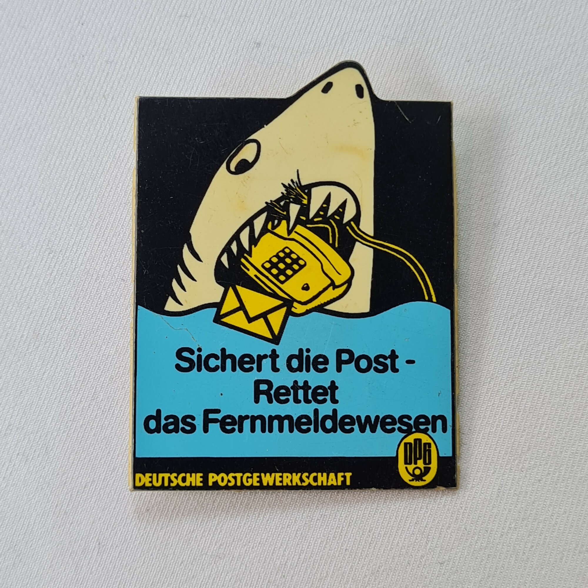 Значок СССР. Акула, письмо и телефон, почта и связь, надпись Deutsche Postgewerkschaft. Винтажный зн