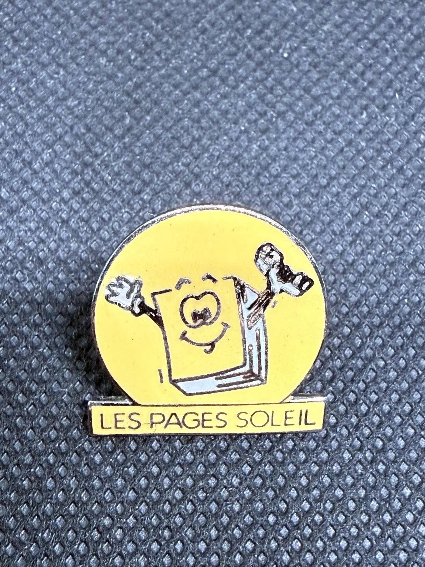 Значок Les Pages Soleil с улыбающейся книгой