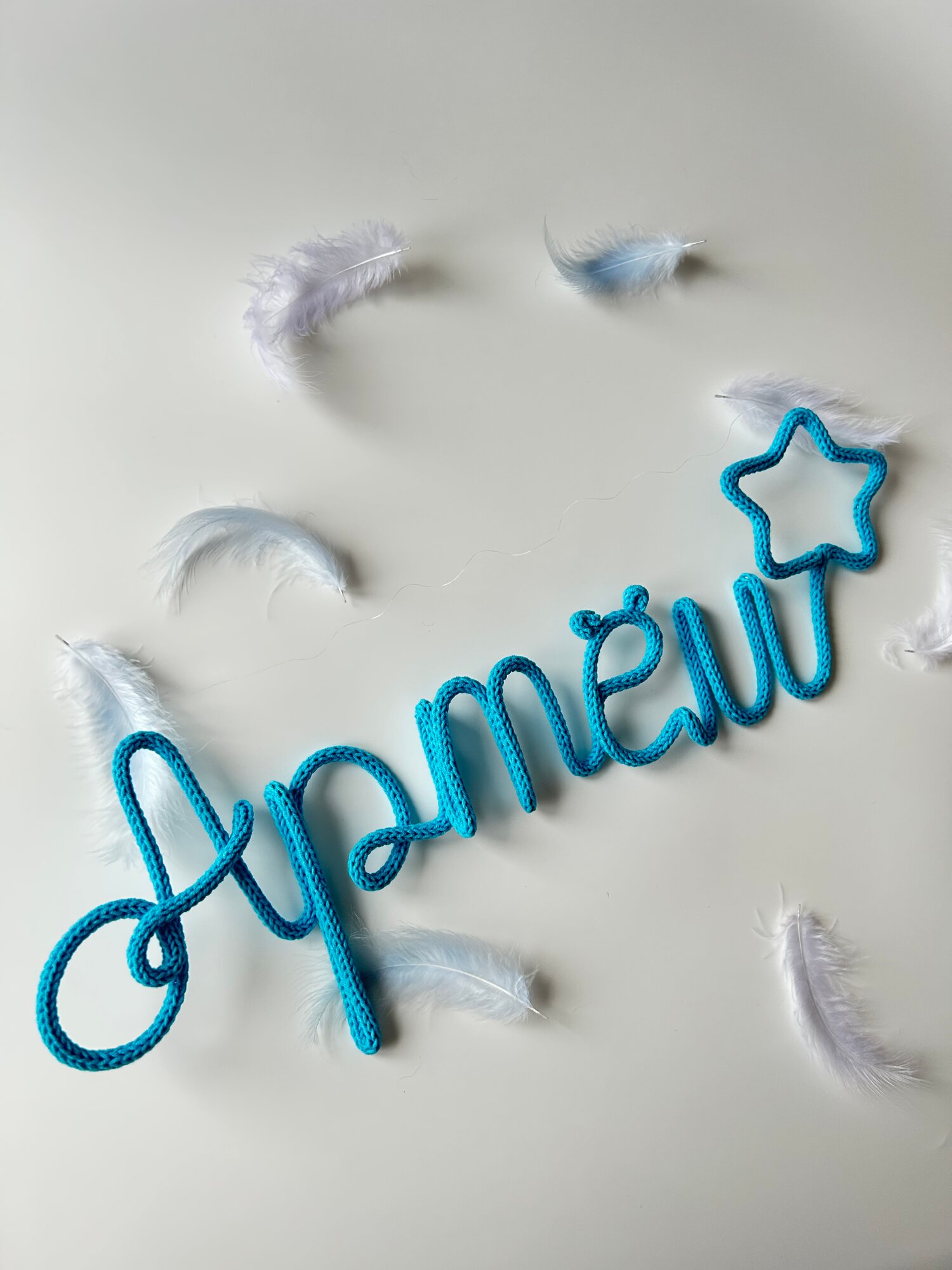 Вязаное имя Артём со звездочкой в технике трикотин в голубом цвете