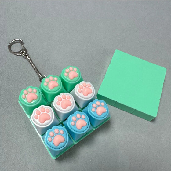 Многоцветная 9-кнопочная антистрессовая силиконовая игрушка-кнопка в виде кошачьей лапки с мультяшным рисунком для тестирования клавиатуры.