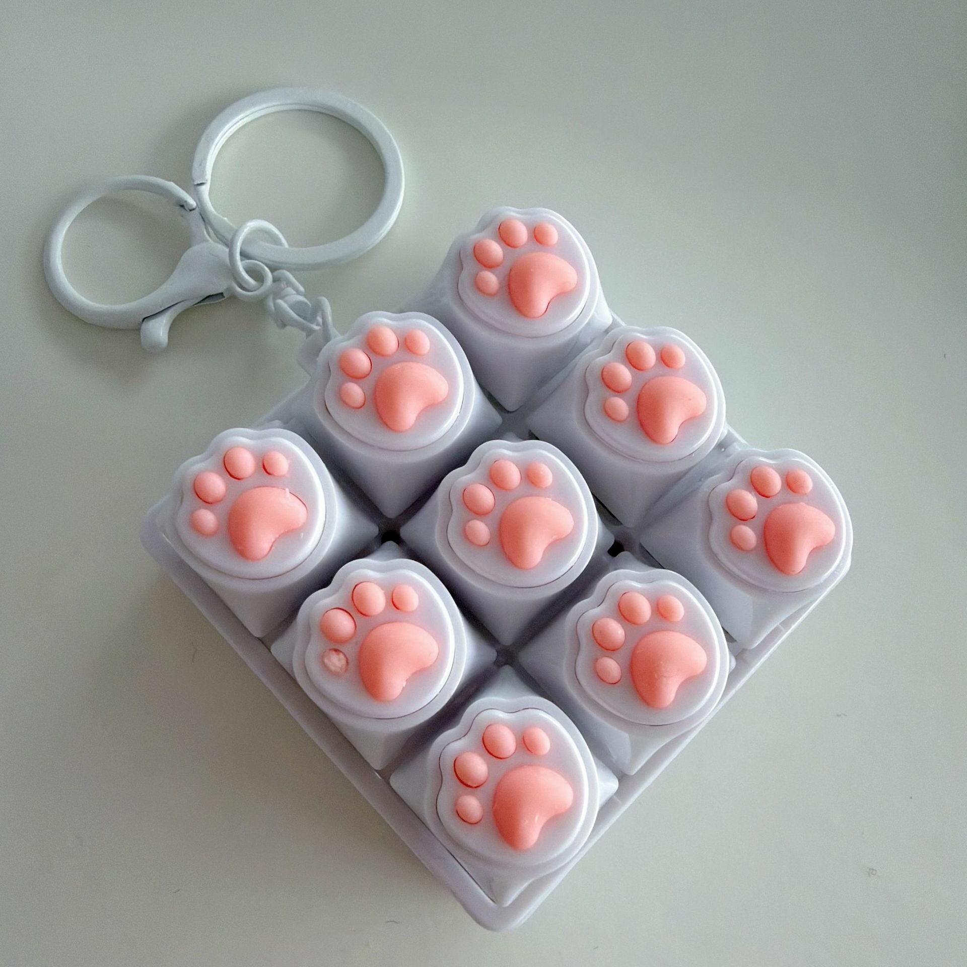 Многоцветная 9-кнопочная антистрессовая силиконовая игрушка-кнопка в виде кошачьей лапки с мультяшным рисунком для тестирования клавиатуры.