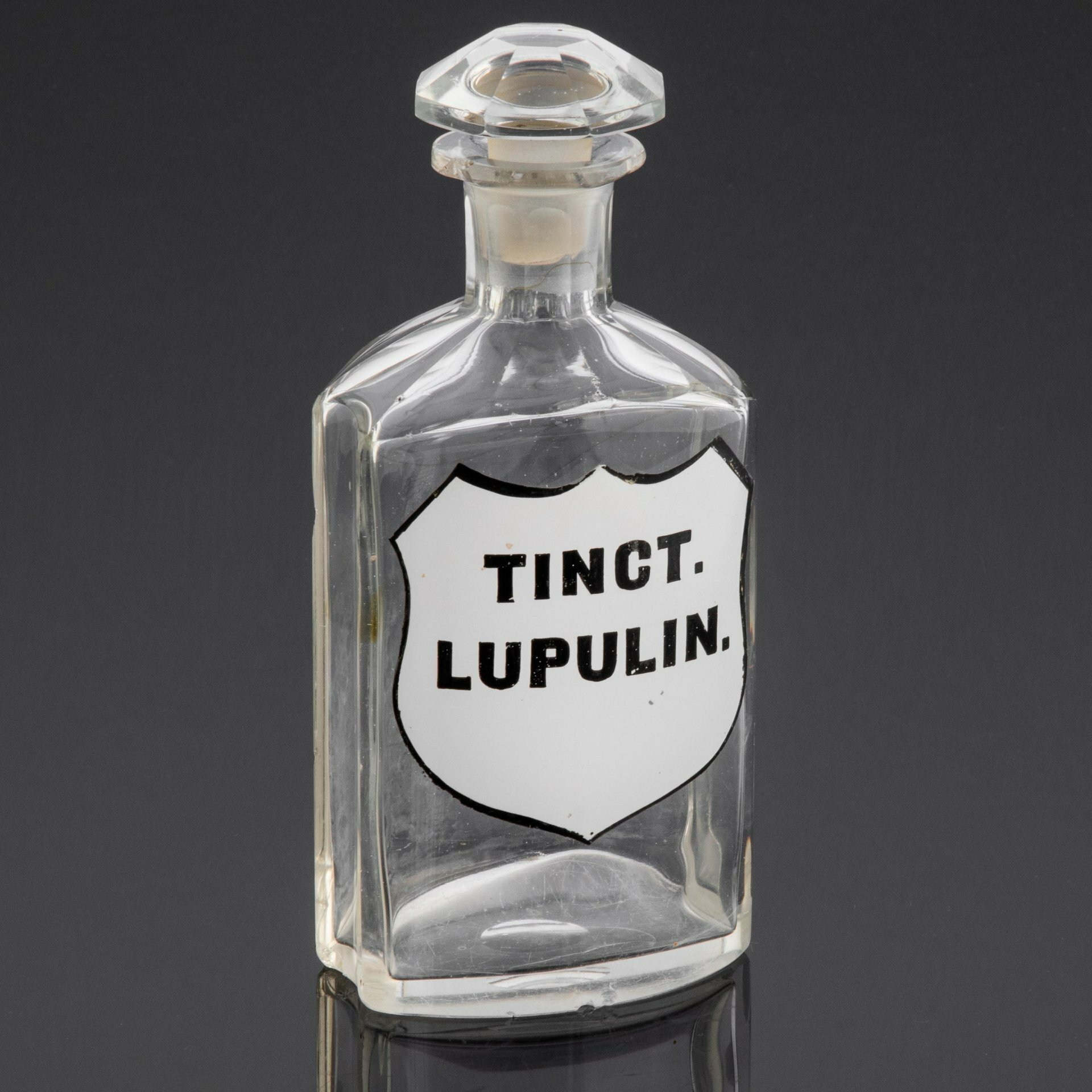 Бутылка (флакон) с надписью в щитке "Tinct. lupulin" (настойка шишек хмеля), стекло