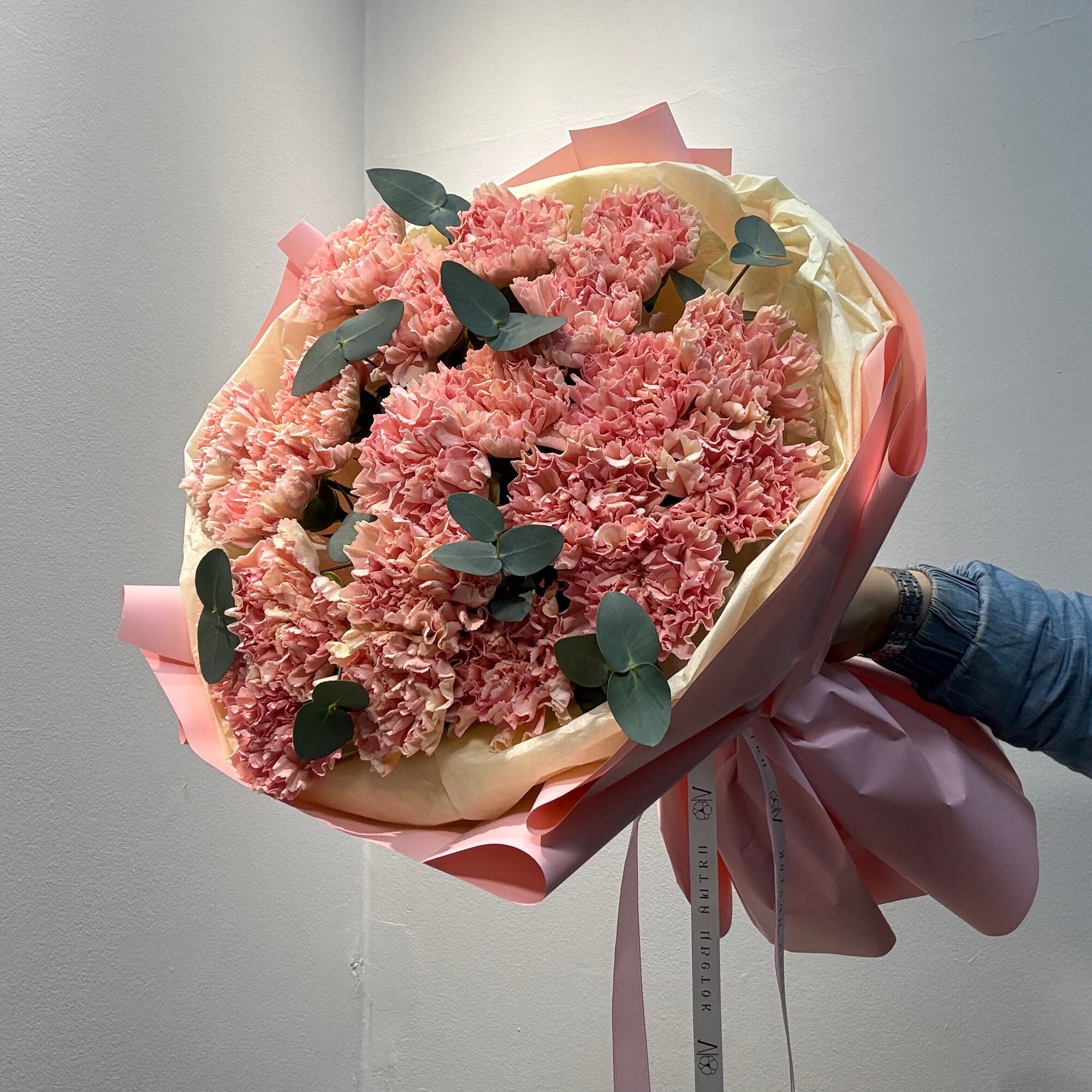 Нежно коралловые диантусы (гвоздики) с эвкалиптом в красивой упаковке «С праздником»