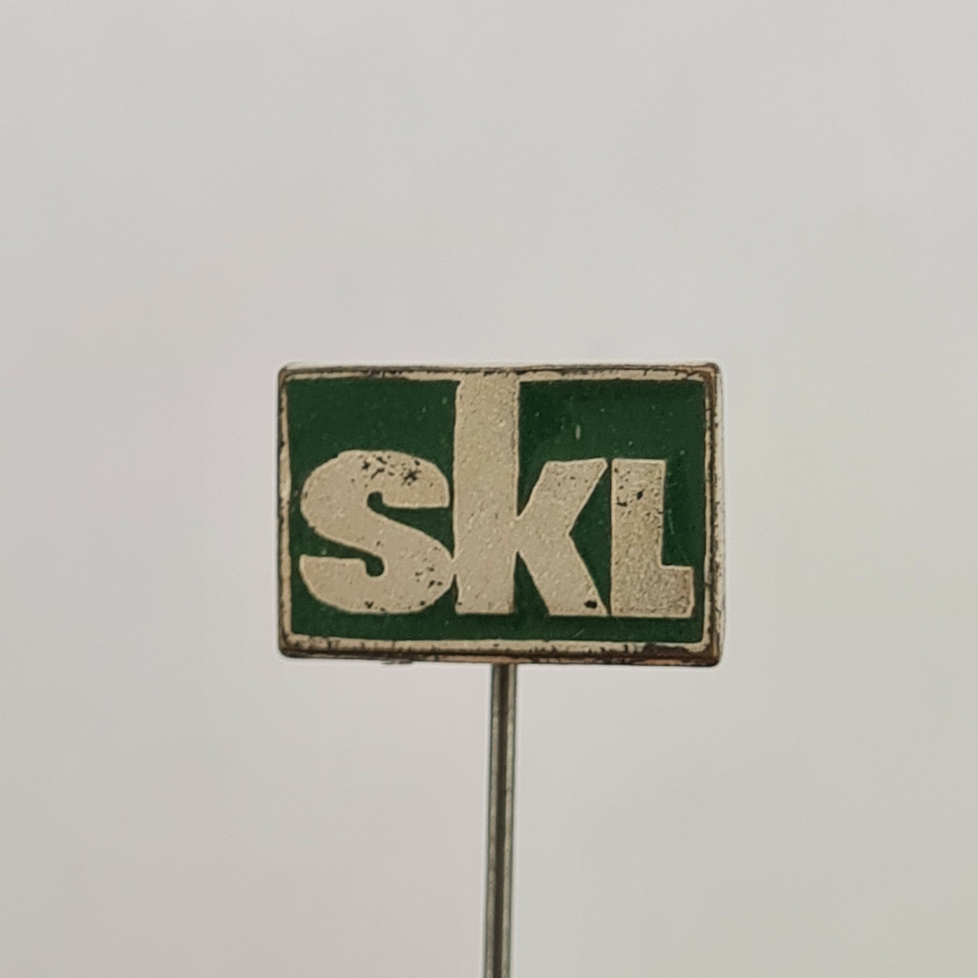 Значок СССР. Надпись SKL, зеленый фон, промышленная тематика. Винтажный значек.