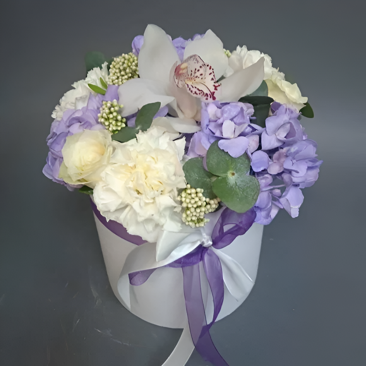 Композиция из орхидей, диантусов и гортензии в шляпной коробке "Вечерний вальс"