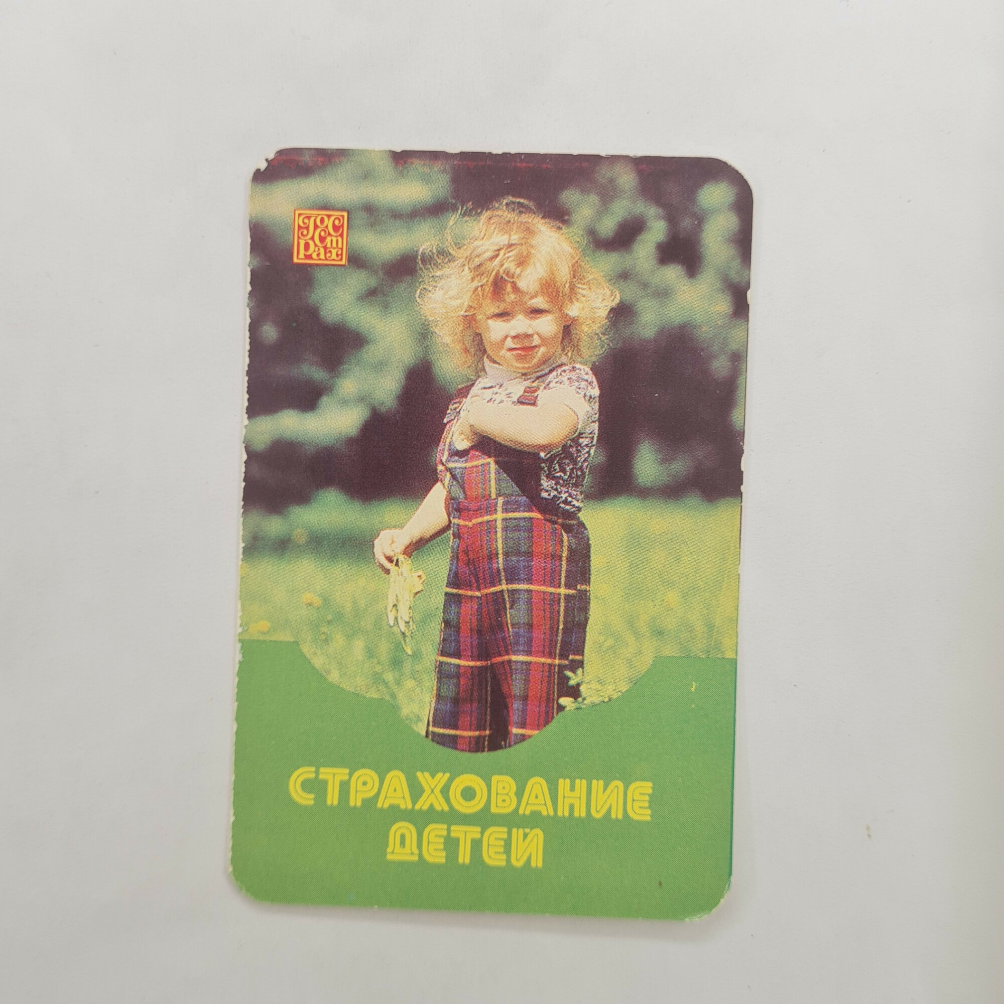 Карманный календарик СССР 1984. Страхование детей, девочка с ромашками на лугу. Советский календарь