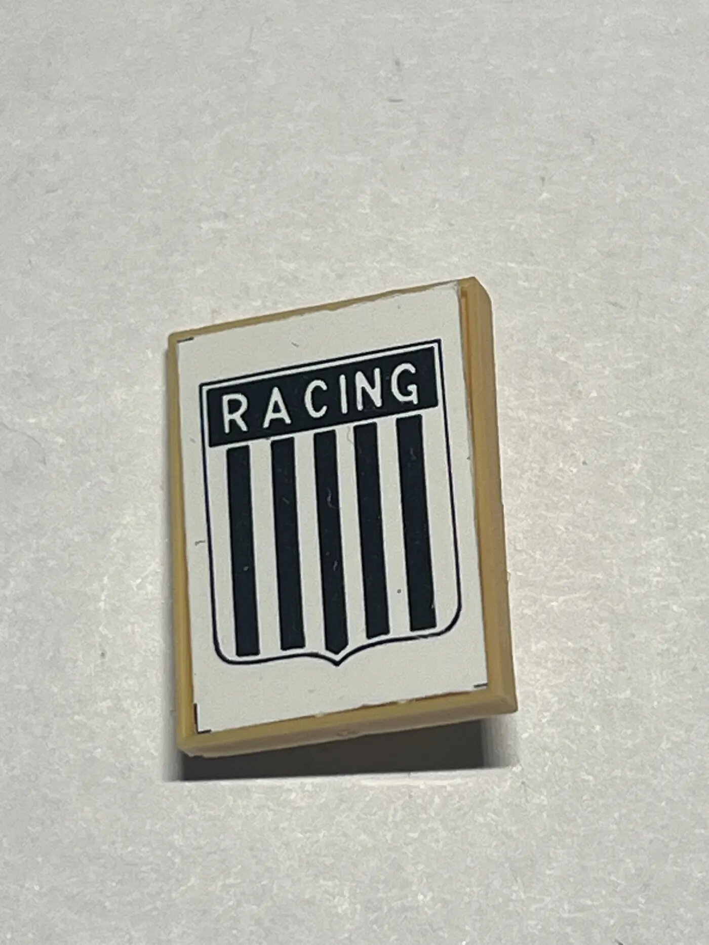 Значок Racing, щит с полосами