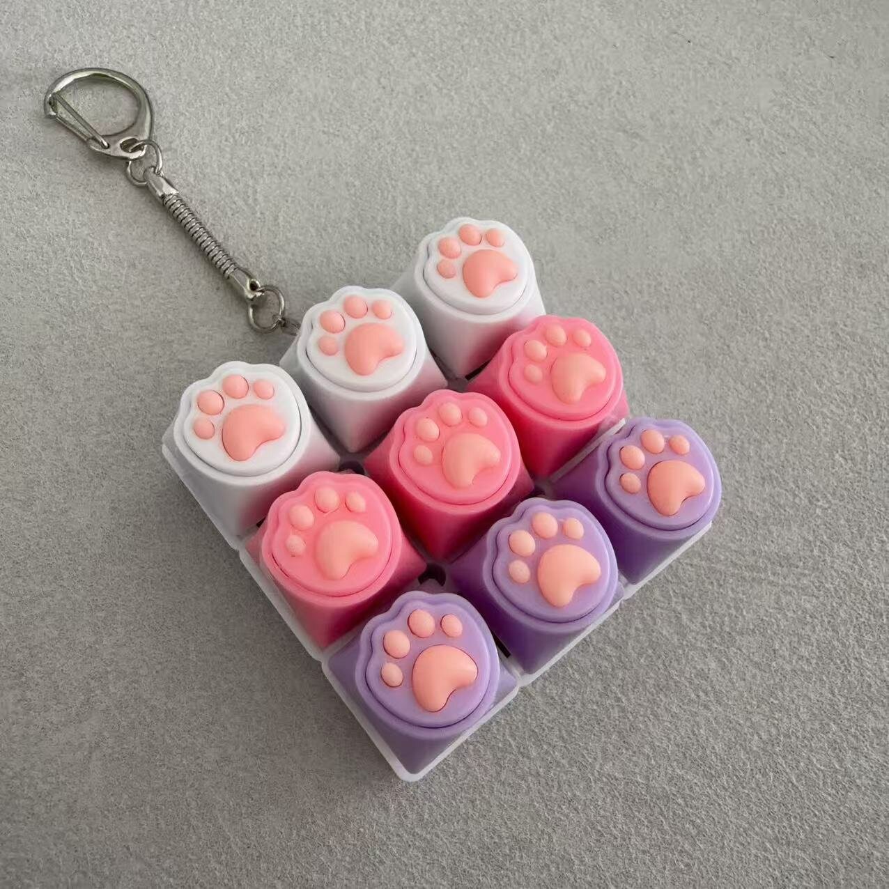 Многоцветная 9-кнопочная антистрессовая силиконовая игрушка-кнопка в виде кошачьей лапки с мультяшным рисунком для тестирования клавиатуры.