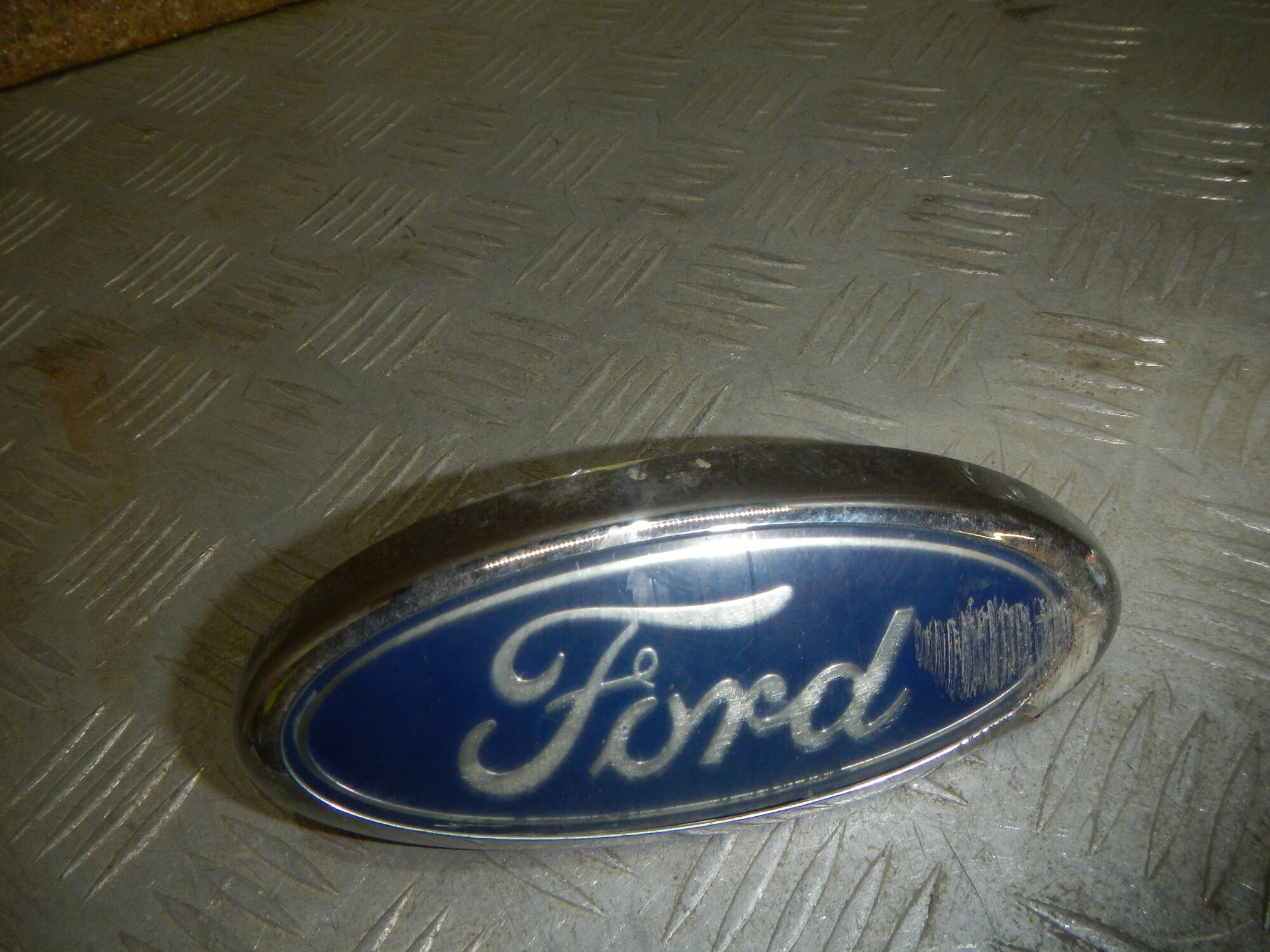 Б/У Эмблема, Ford (Форд)-FOCUS 2 (05-08) FORD FOCUS 2 (05-08) Задиры. 517167 FORD арт. 4M518216AA