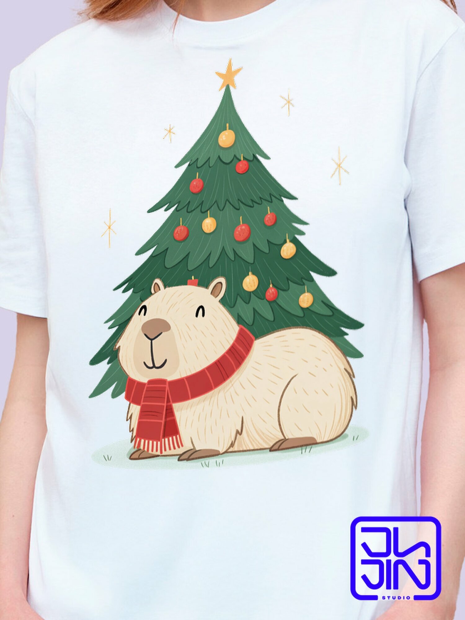 Футболка классическая женская с авторским принтом Смешная капибара с мемами у темно-зеленой елки на зеленом рождественском фоне, белый хлопковый трикотаж с прикольным рисунком на груди