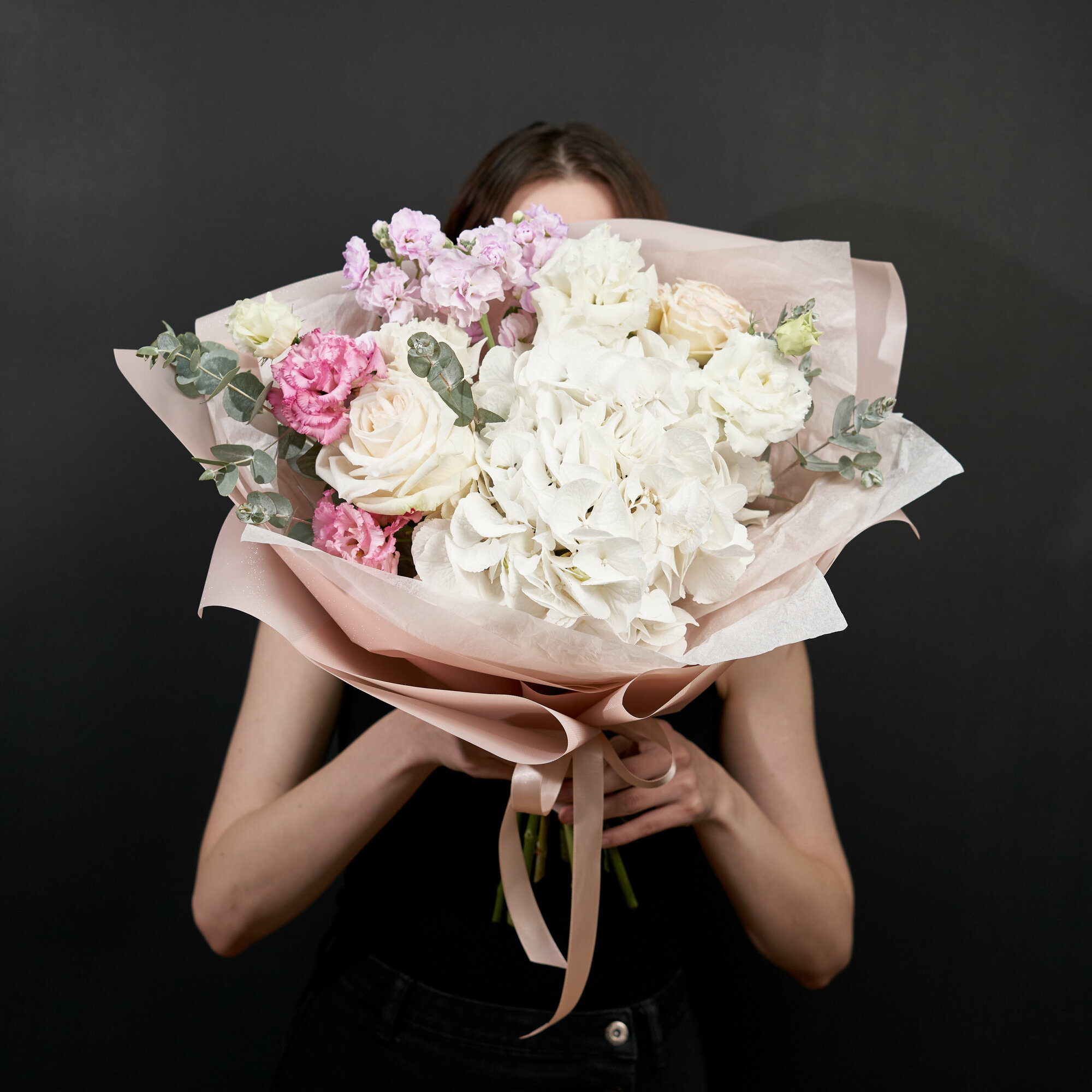 Маленький букет живых цветов с белыми гортензиями и розами в пышной подарочной упаковке