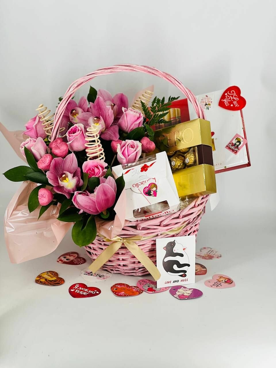 Подарочная корзина с букетом из роз, орхидеи, рускуса и конфетами рафаэлло, ферреро роше и мерси.