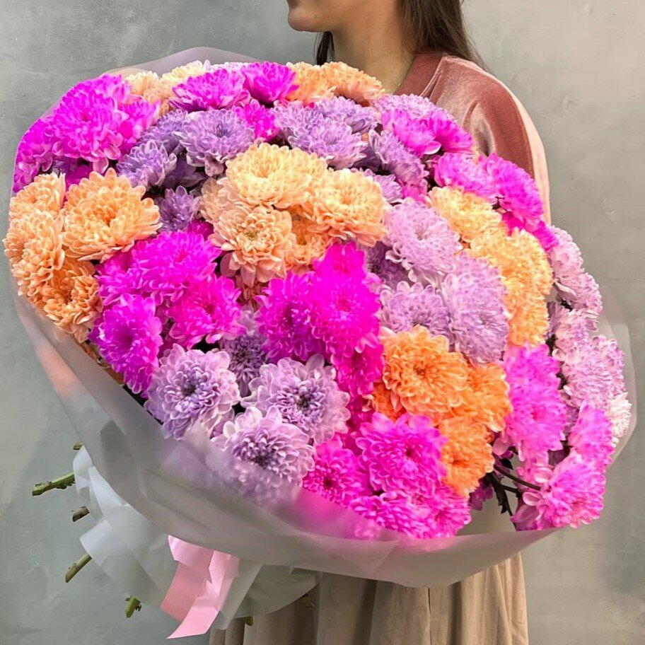 Огромный букет из яркой, радужной, насыщенной хризантемы в дизайнерской, матовой пленке с лентой.
