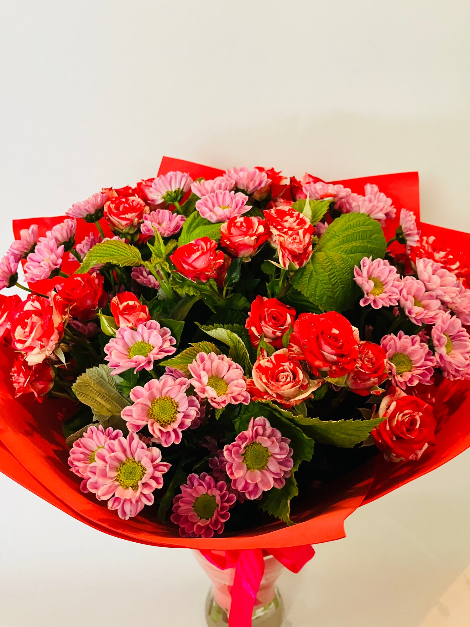 Букет из кустовых роз Фейерверк и розовых хризантем сантини Росси розовая, в красной, дизайнерской упаковке, атласный бант.