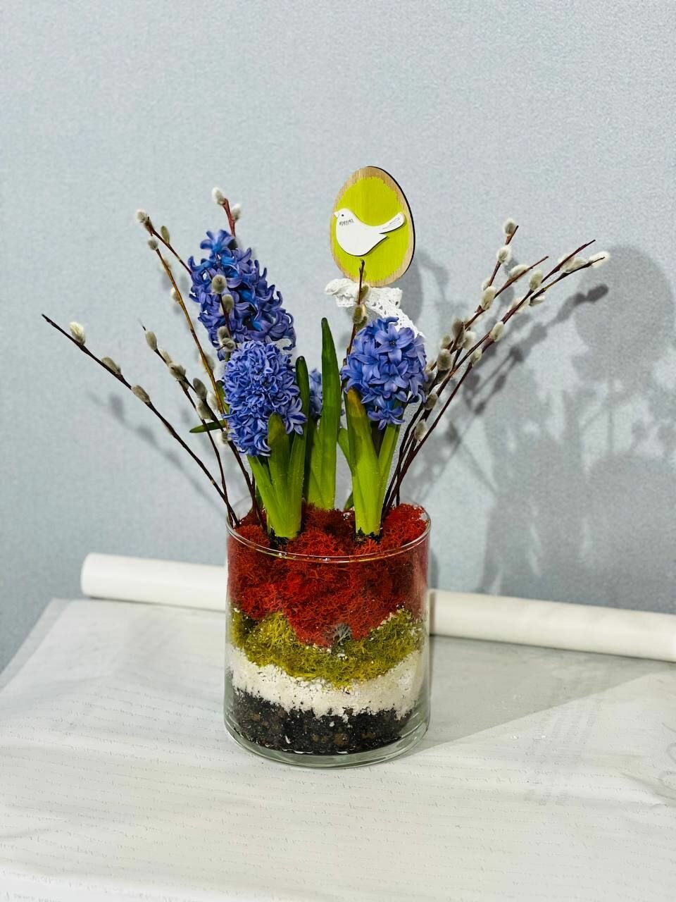 Пасхальная композиция с вербой и первоцветами гиацинт в стеклянной вазе